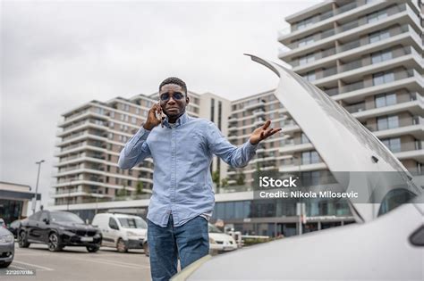 남자가 부서진 차 옆에 서서 도움을 청하는 전화를 걸고 있습니다 Brand Name Domestic Car에 대한 스톡 사진 및 기타 이미지 Brand Name