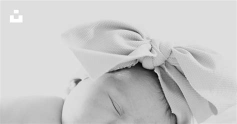 흰 옷차림에 누워 있는 흰 모자를 쓴 아기 사진 Unsplash의 무료 회색 이미지