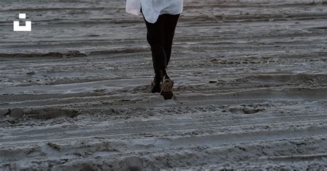 흰색 긴팔 셔츠와 검은 바지를 입은 여자가 일몰 동안 해변에 서 있다 사진 Unsplash의 무료 바닷가 이미지