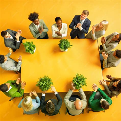 A Group Of People Sit Around A Table With A Yellow Background Premium
