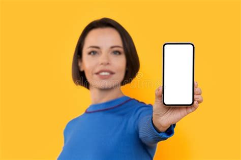 Online Offer Young Smiling Female Holding Smartphone With Blank White Screen Stock Image