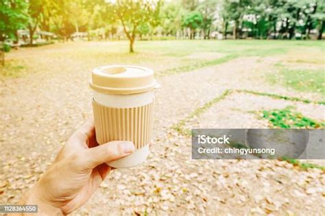 남자의 손 영감 아침 뜨거운 음료 걸릴 멀리 종이 커피 컵을 들고 추상 공원 배경에서 볼 소프트 선택 초점입니다 공간에 복사 합니다 가을에 대한 스톡 사진 및 기타 이미지