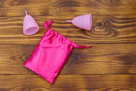 나무 배경에 핑크 재사용 실리콘 생리컵 과 실크 가방 두 개 맨 위 보기 여성 위생 부인과 및 건강의 개념 0명에 대한 스톡 사진 및 기타 이미지 Istock