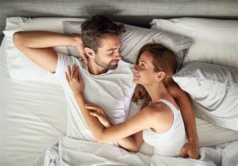 Love In Lazy Mode A Happy Young Couple Relaxing In Bed Together At