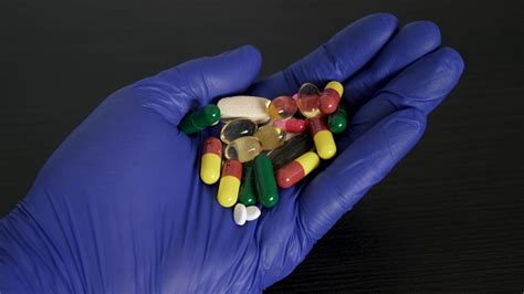 의료용 장갑을 낀 남자가 손바닥에 다양한 알약을 들고 있습니다 건강 관리 치료 및 질병 예방에 관한 주제 0명에 대한 스톡 사진 및 기타 이미지 Istock