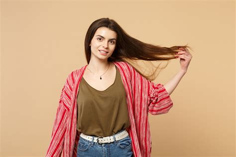 캐주얼 한 옷 카메라 스튜디오에서 파스텔 베이 지 벽 배경에 고립 된 머리를 들고에서 아름 다운 젊은 여자의 초상화 사람들은 진심으로 감정 라이프 스타일 개념입니다 복사