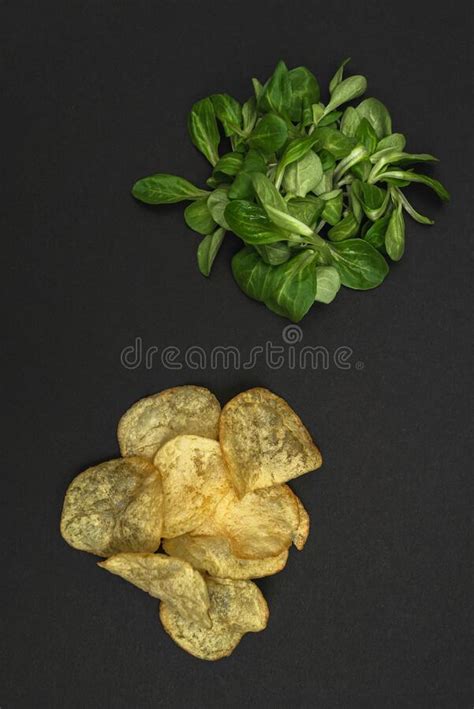 Lettuce Leaves And Chips On A Black Background Healthy And Unhealthy