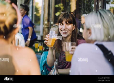 Happy Transgender Woman Talking While Enjoying Juice With Non Binary
