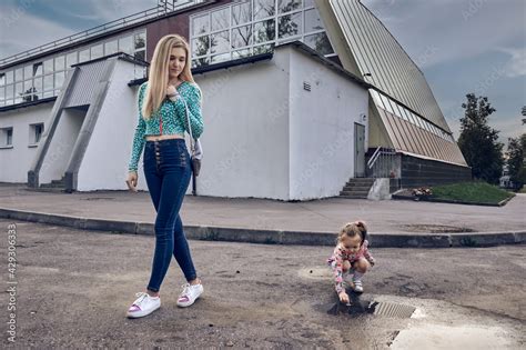 Mom Watches Her Daughter Play Summer Evening After The Rain Summer Walk Puddles The Sports