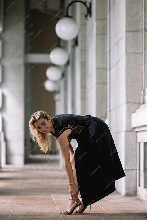 Premium Photo A Woman In A Black Dress Is Bending Over A Wall With A