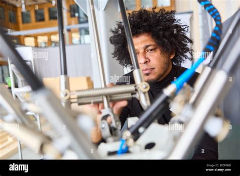 Focused Engineer Fine Tuning A Robot Gripper Arm In A Modern Workshop