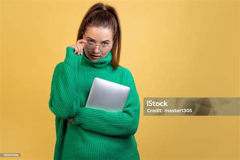 노란 스튜디오 배경에 고립 된 가젯을 사용하여 녹색 스웨터를 입은 어린 귀여운 소녀의 반 길이 초상화 감정 패션의 개념 25 29세에 대한 스톡 사진 및 기타 이미지