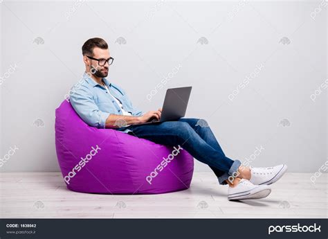 عکس نمایه تمام قد از پسر جذابی که نوت بوک در دست دارد در حال مرور همکاران در حال چت کردن است که
