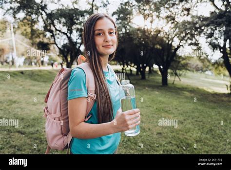 Teenage Girl Wearing Turquoise T Shirt And A Pink Backpack Holding A