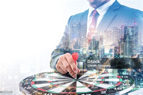 사업 지주 화살표와 함께 다트 보드의 더블 노출 시 밤 배경 흐림 승리 개념에 목표를 달성 하기 강박에 대한 스톡 사진 및 기타