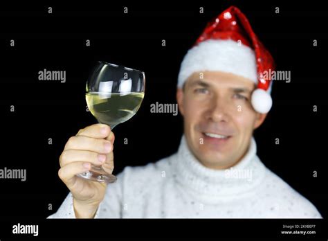 Wine Glass In Hand Of Happy Man In Santa Claus Hat On Black Background