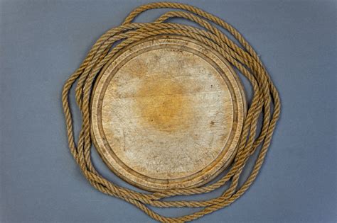 배의 밧줄이 커팅 보드를 감쌌습니다 둥근 빈 나무 커팅 보드와 회색 배경에 대한 배의 로프 0명에 대한 스톡 사진 및 기타