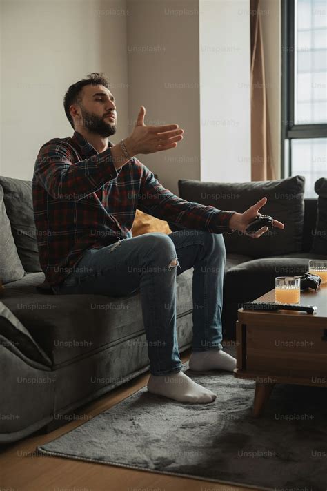 소파에 앉아 팔을 허공에 대고 있는 남자 사진 Unsplash의 승리 이미지