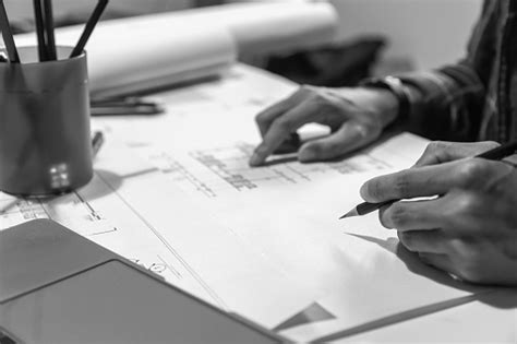 컨셉 아키텍트 엔지니어 왼손잡이 홀딩 펜 포인팅 장비 그린 노트북 사무실에서 청사진과 책상에흑백 사진 개념에 대한 스톡 사진 및 기타 이미지 Istock