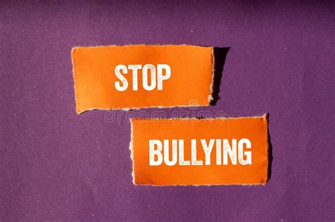 Stop Bullying Message Written On Ripped Torn Orange Paper Pieces On