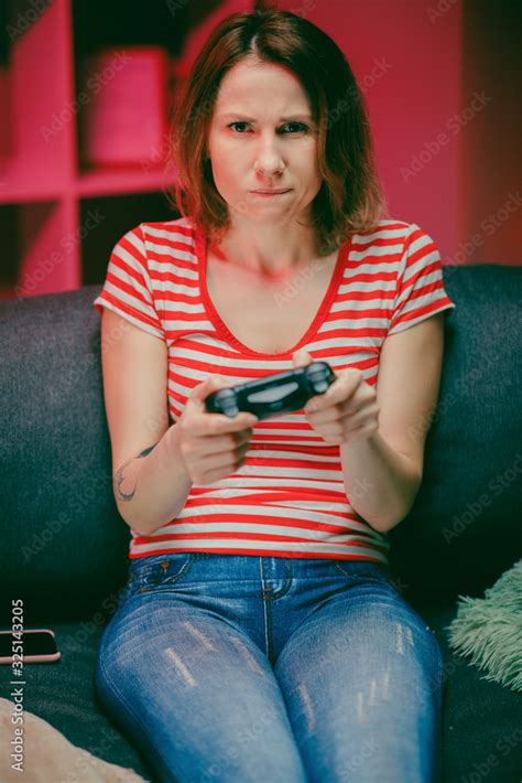 Girl Playing A Video Game At Living Room At Night Gamer Woman Sitting On A Sofa Playing In