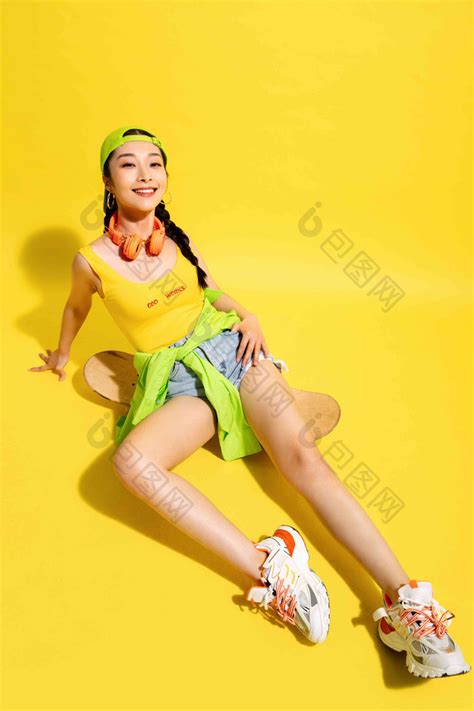 坐在滑板上休息的青年女人 包图企业站
