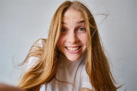 흰 티셔츠를 입은 여자가 흰 벽 근처에서 포즈를 취한다 손짓과 감정 스튜디오 사진 감정 힘 재미의 개념 캐주얼 비문과 로고를 위한 공간 T 셔츠에 대한 스톡 사진 및 기타