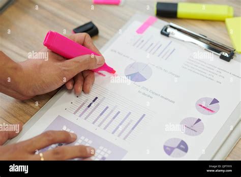 Hands Of Manager Highlighing Important Figures In Report With Bright