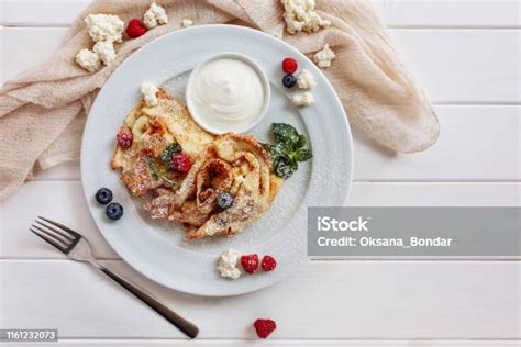 코티지 치즈와 팬케이크의 클로즈업및 딸기 민트 잎으로 장식 된 흰색 접시 배경에 접시에 블루 베리 가루 설탕에 대한 스톡 사진 및 기타 이미지 Istock