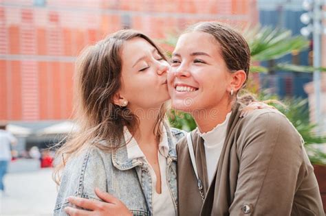 Joyful Moment Of Affection Between Two Female Friends As One Gives A