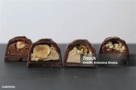 헤이즐넛 땅콩 프랄린 초콜릿이 들어간 네 개의 초콜릿 케이스 캔디가 회색 배경에 클로즈업되어 카피스페이스 텍스트용 공간이 있습니다 0명에 대한 스톡 사진 및 기타 이미지