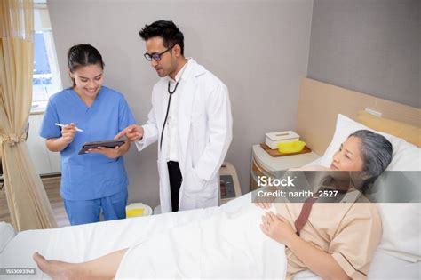 전문 의사와 간호사가 병원에 있는 노인 환자 의료 및 병자 태블릿에 의료 및 건강 관리를 보고하여 진단 질병 노인 및 몸이 좋지 않은 환자를 설명하고 확인합니다 간호사에