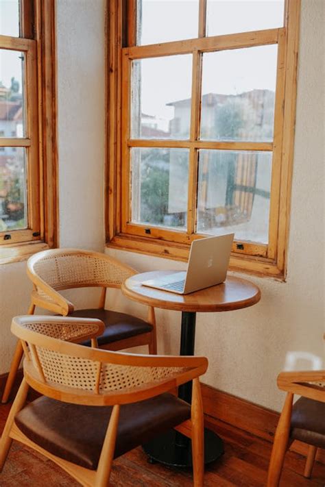 노트북과 의자가 있는 아늑한 햇살이 비치는 코너 · 무료 스톡 사진