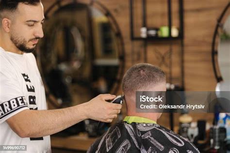 남자의 머리를 자르는 잘생긴 미용사의 뒷모습 이발소에서 고객에게 서비스를 제공하는 헤어스타일리스트 20 29세에 대한 스톡 사진
