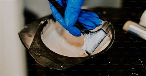 장갑을 끼고 파란색 장갑을 끼고 검은 물체를 들고 있는 사람 사진 Unsplash의 머리 표백제 이미지