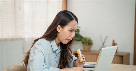 아시아 매력적인 사업가는 노트북 컴퓨터에서 사업을 실행하는 동안 서둘러 입 가득 빵을 먹고 배고프다 아름답고 진지한 학생은