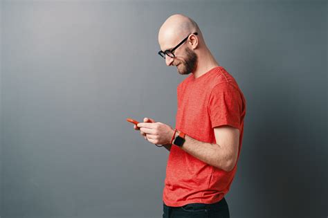 회색 스튜디오 배경에 전화로 말하는 수염 안경 빨간 티셔츠를 가진 잘 생긴 털이 없는 백인 남자 30 39세에 대한 스톡 사진 및 기타 이미지 Istock