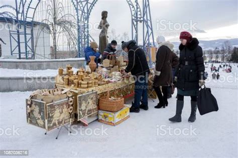 사람들이 겨울 새 해 휴일 동안 크라스노야르스크의 센터에서 박람회에 자작나무 껍질에서 전통적인 러시아 기념품을 구입 거리에 대한