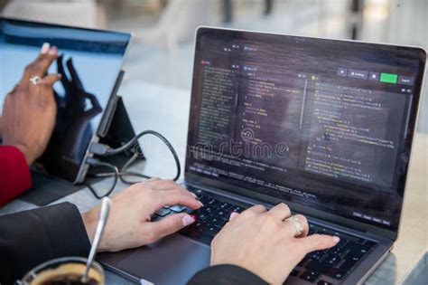 Female Programmer Writes Some Code And Drinks Coffee While Sitting Near