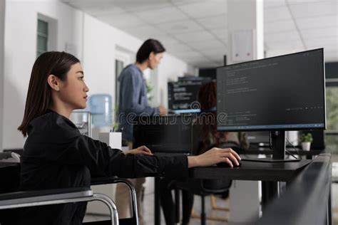 web developer in wheelchair working on server coding in big data office