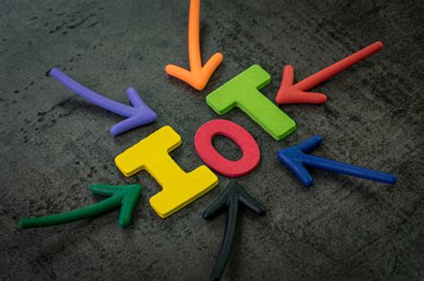 Iot 사물 인터넷 인터넷 개념에 연결할 수 있는 장치 검은 시멘트 칠판 벽의 중심에 있는 Iot라는 단어를 가리키는 다색