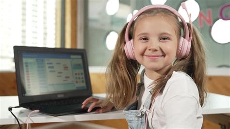 Premium Photo Smiling Girl Looking At Camera With Laptop Displayed