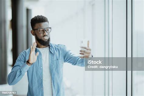 쾌활한 성공적인 젊은 아프리카 계 미국인 매니저의 실내 사무실 샷 과 전화 웨이브 인사말 에 화상 통화 Comunication 기업가에 대한 스톡 사진 및 기타 이미지