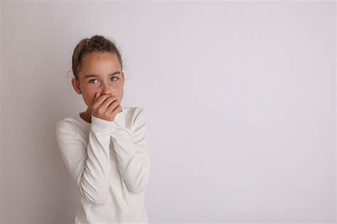 흰색 셔츠를 입은 11 12세의 고립된 흰색 배경에 있는 작은 감정적 십대 소녀 어린이 스튜디오 초상화 텍스트를 배치하여 비문 공간을 복사하고 어린이 용품을 광고합니다 8