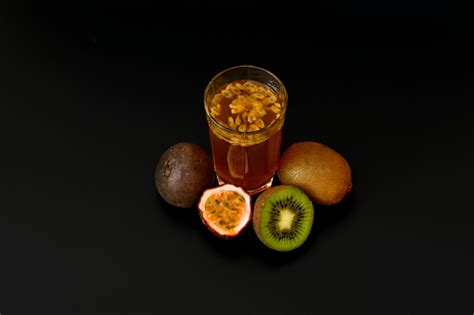 귤 조각과 잘 익은 패션 프루트 옆에 검은 배경에 씨앗이 있는 과일 주스가 섞인 키가 큰 유리잔 0명에 대한 스톡 사진 및 기타 이미지 Istock