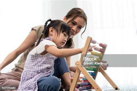 아시아의 아름다운 사랑하는 엄마는 집에서 딸과 함께 교육 게임을합니다 매력적인 여성 부모는 어린 소녀 아이와 함께 무료 여가 시간을 보내고 아이의 장난감으로 기술을 배우고