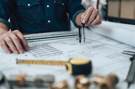 사무실 책상과 계산기 삼각형 눈금자 안전 안경 나침반 블루프린트의 버니어 캘리퍼에서 도면 검사 및 쓰기로 작업하는 엔지니어링 엔지니어 건축가 산업 및 공장 개념 35 39