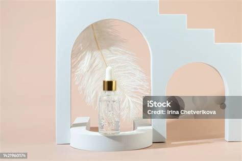 투명한 천연 유기농 세럼 또는 베이지 색 배경에 흰색 아치에 서있는 얼굴 관리를위한 에센셜 오일 피펫에 대한 스톡 사진 및 기타