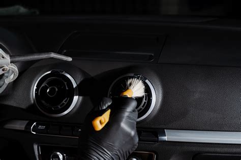 자동차의 에어컨 시스템의 공기와 브러시로 청소합니다 자동차 내부의 자동차 서비스 깨끗한 요소를 자세히 설명하는 작업자 고무에