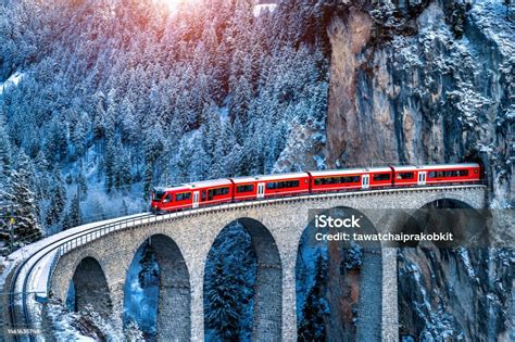 스위스 필리수르의 유명한 산을 통과하는 기차의 공중 전망 란트바서 육교 세계 유산과 스위스 알프스의 눈 겨울 풍경에 특급 열차가 있습니다 피즈 베르니나에 대한 스톡 사진 및